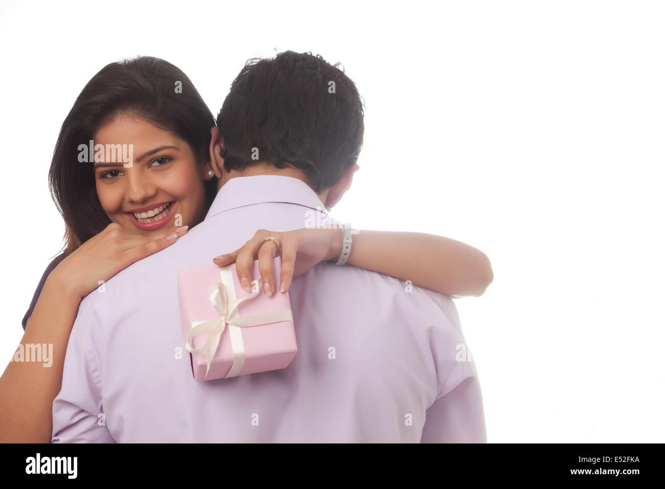 Rear view of a woman with a gift hugging Stock Photo - Alamy