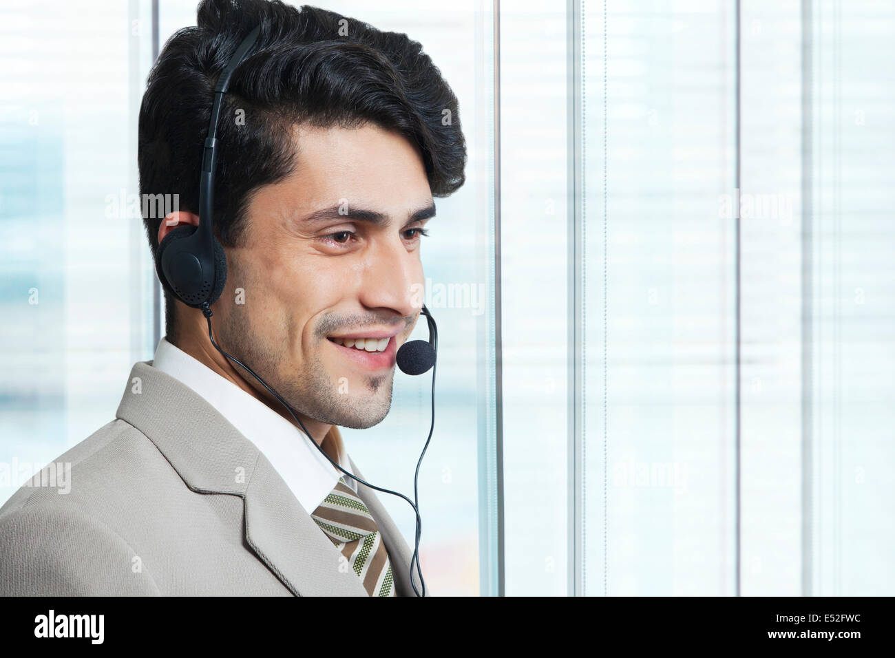 Male customer service representative looking away in office Stock Photo ...