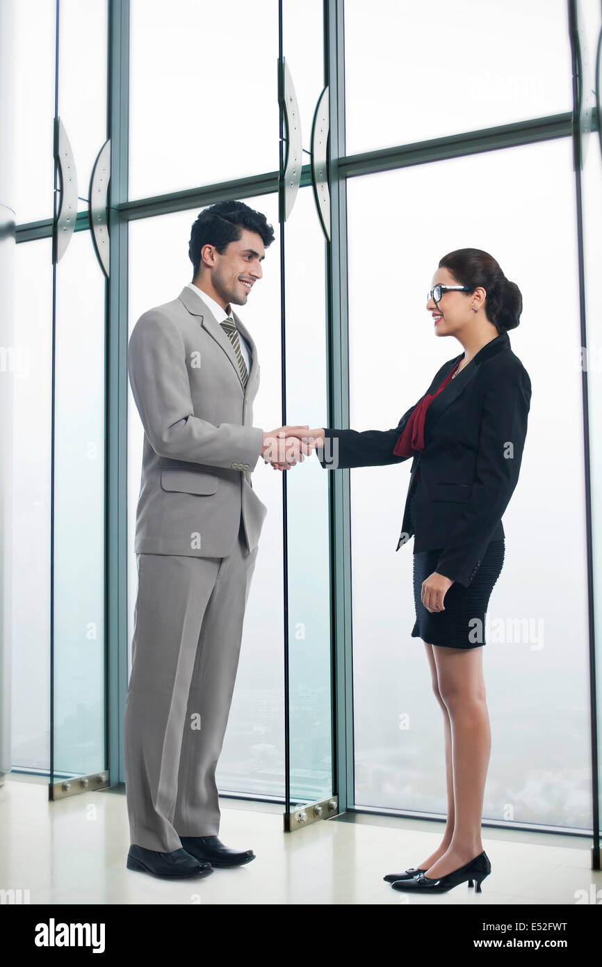 Full length of business people shaking hands in office Stock Photo - Alamy