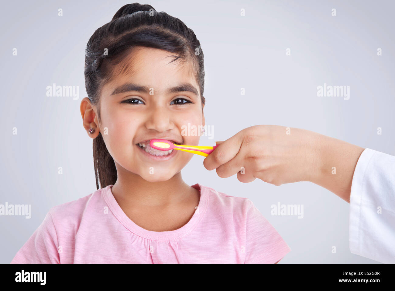 Portrait of little girl getting teeth brushed Stock Photo - Alamy
