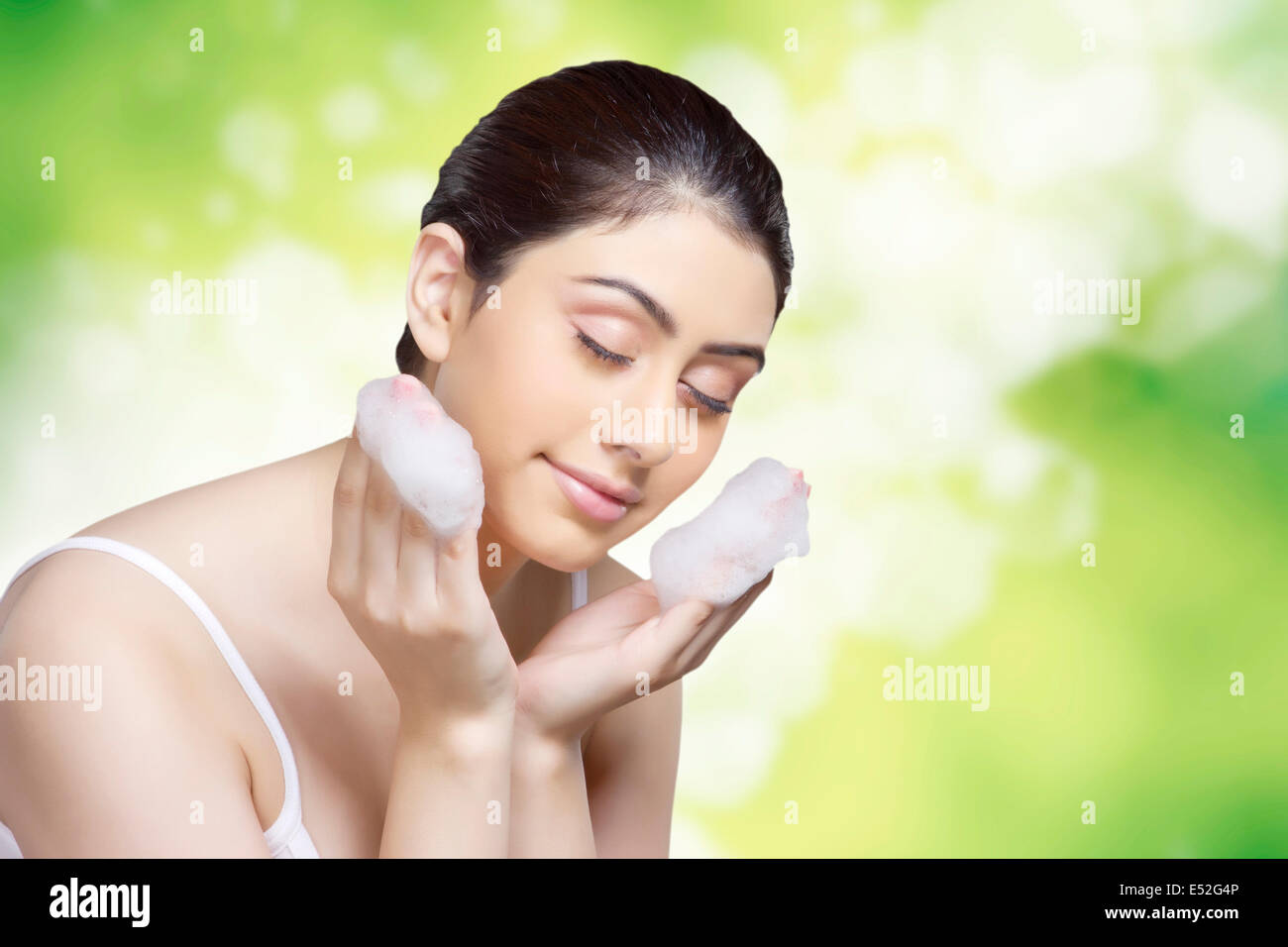 Beautiful young woman applying soap sud on face Stock Photo - Alamy