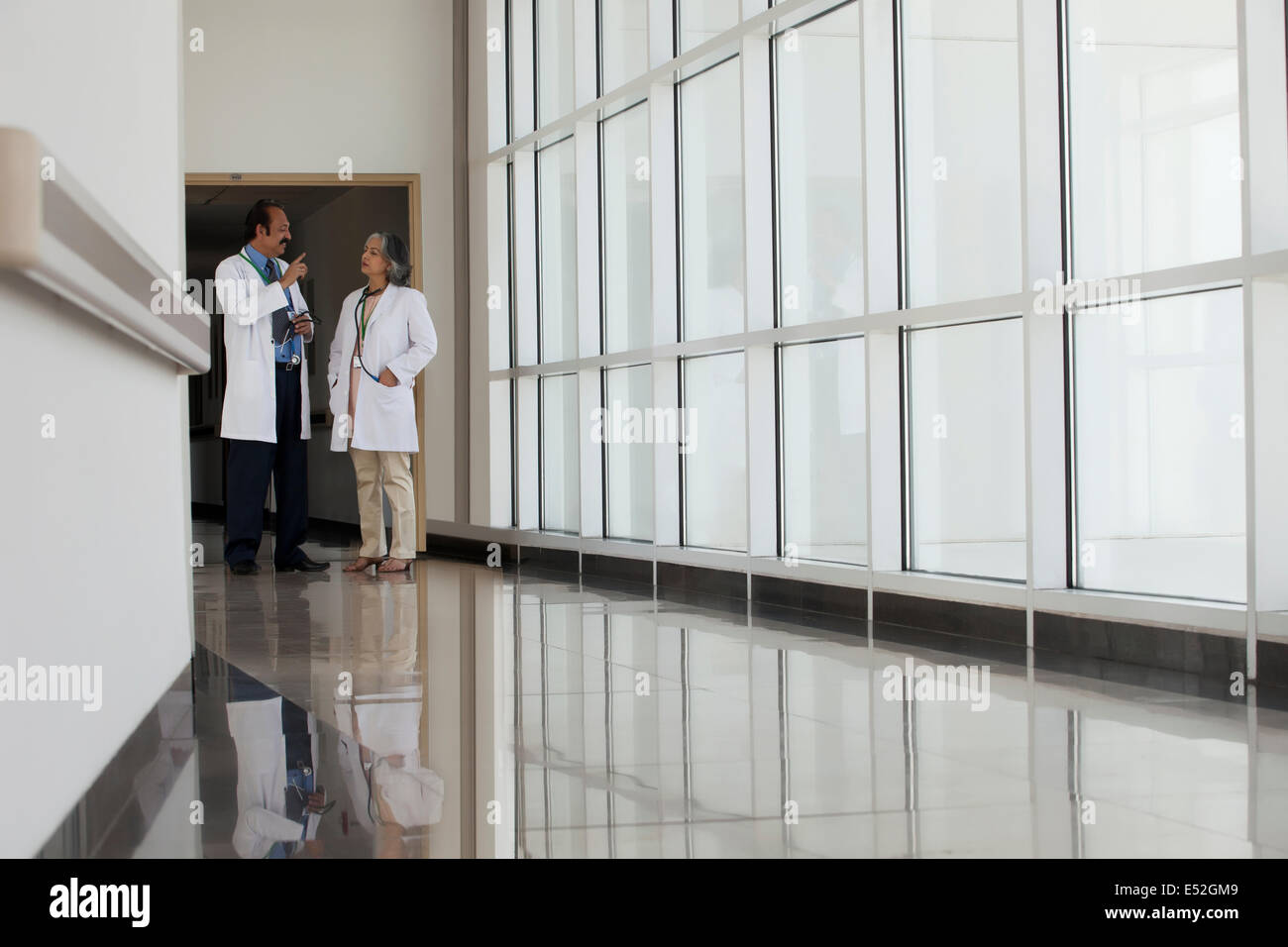Two doctors talking in hospital corridor Stock Photo - Alamy