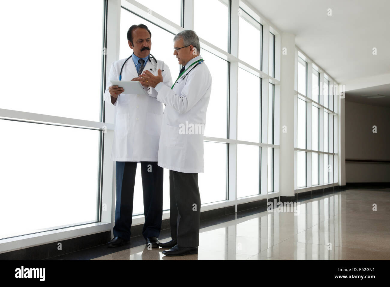 Two doctors talking in corridor of hospital Stock Photo - Alamy