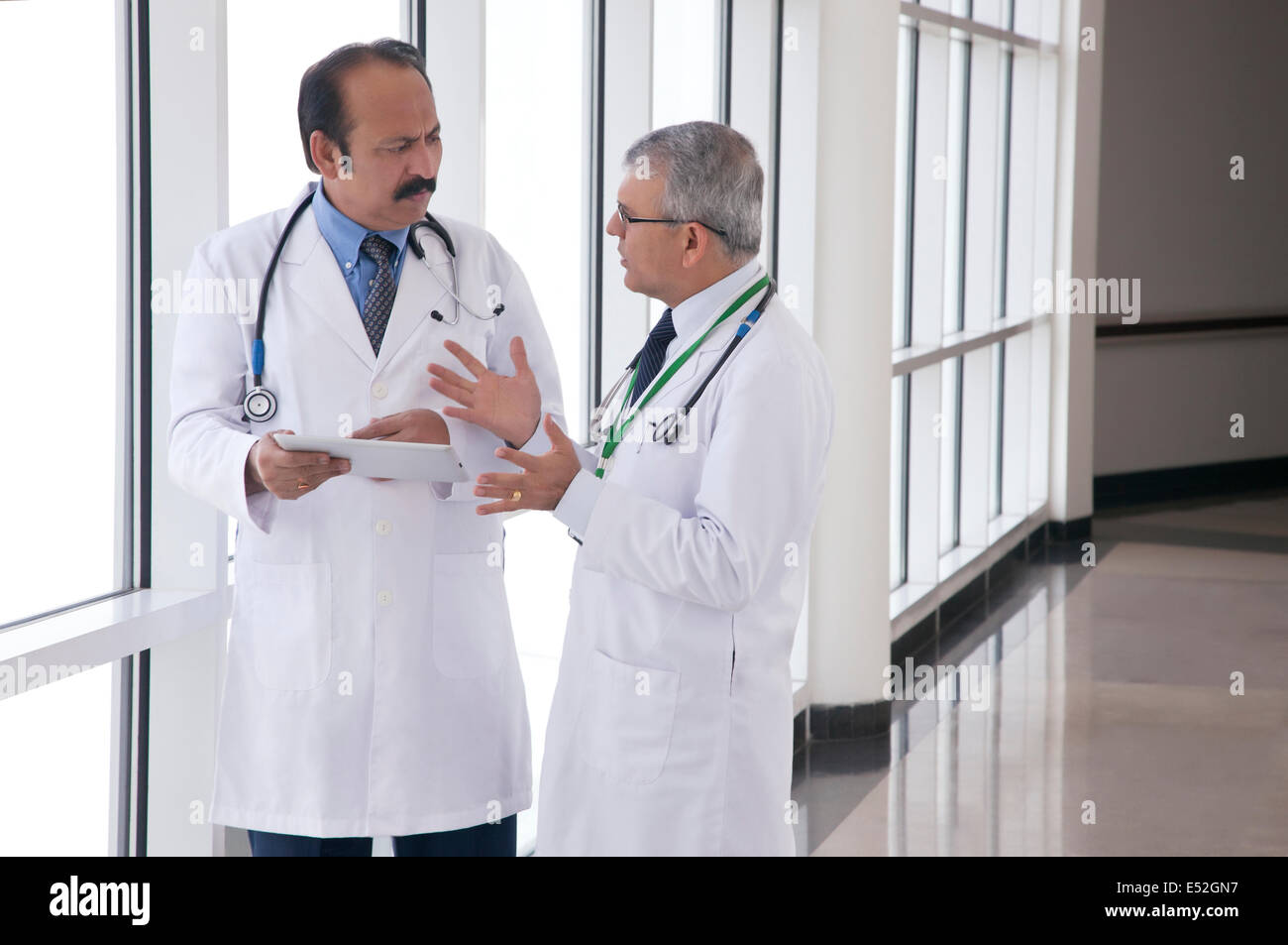 Two doctors talking in corridor of hospital Stock Photo - Alamy