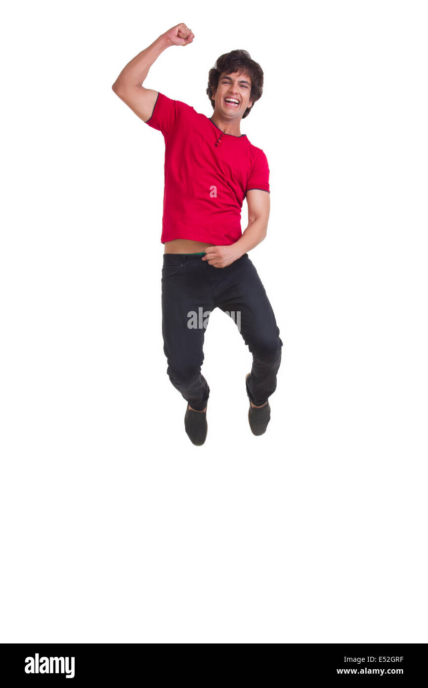 Full length of young man cheering and jumping isolated over white ...