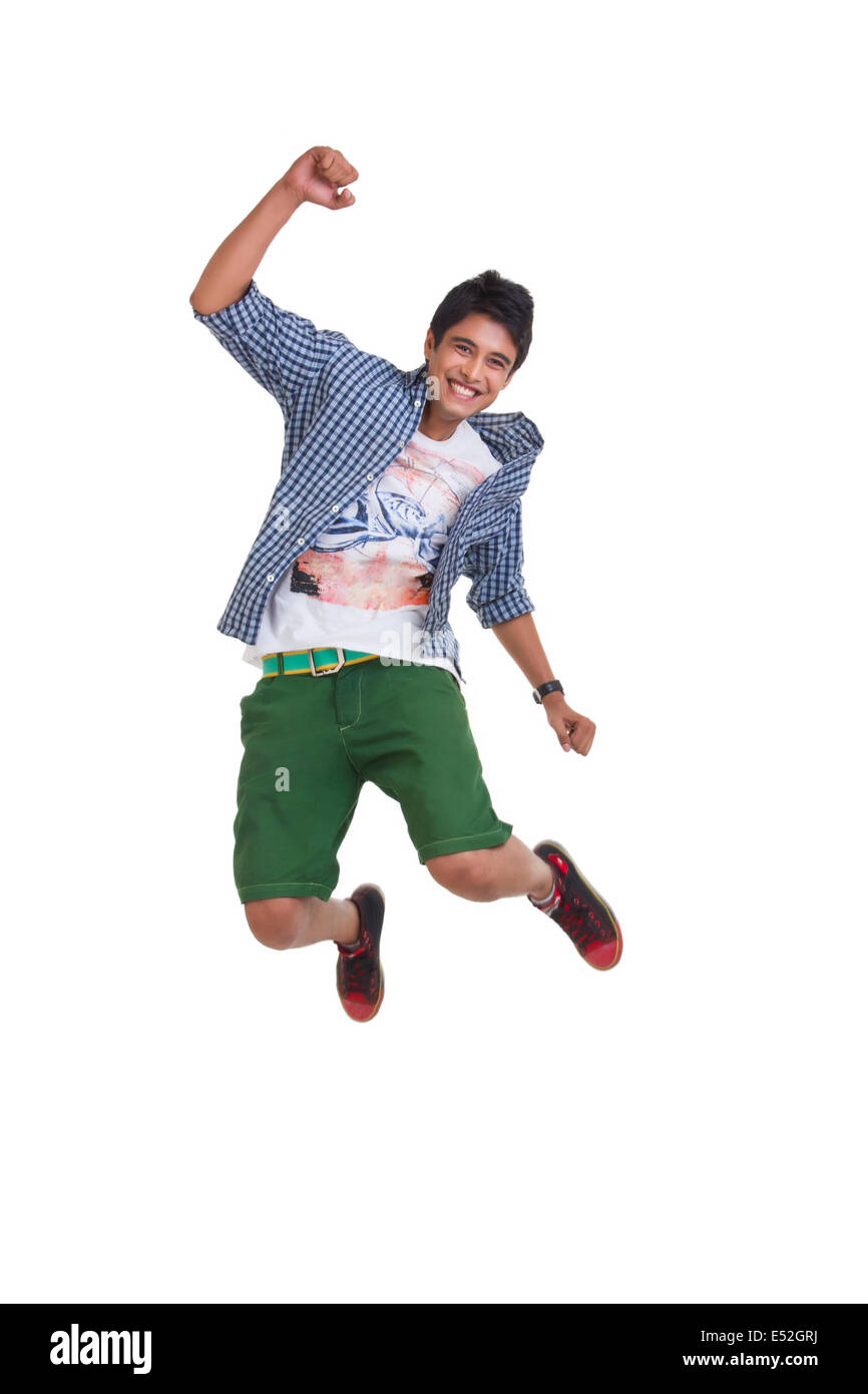 Full length of young man jumping excitedly over white background Stock ...