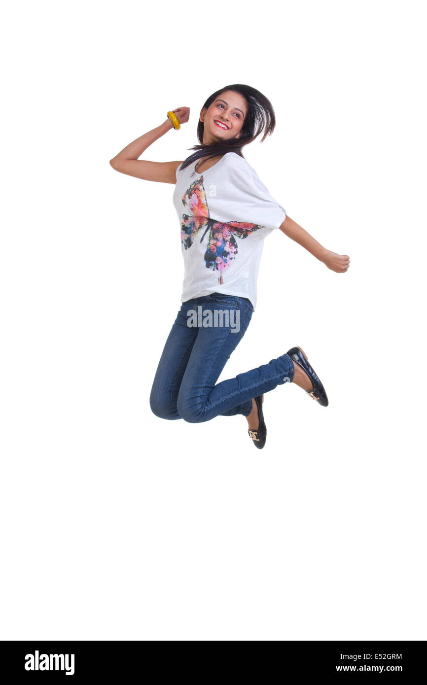 Full length of excited young woman jumping over white background Stock ...