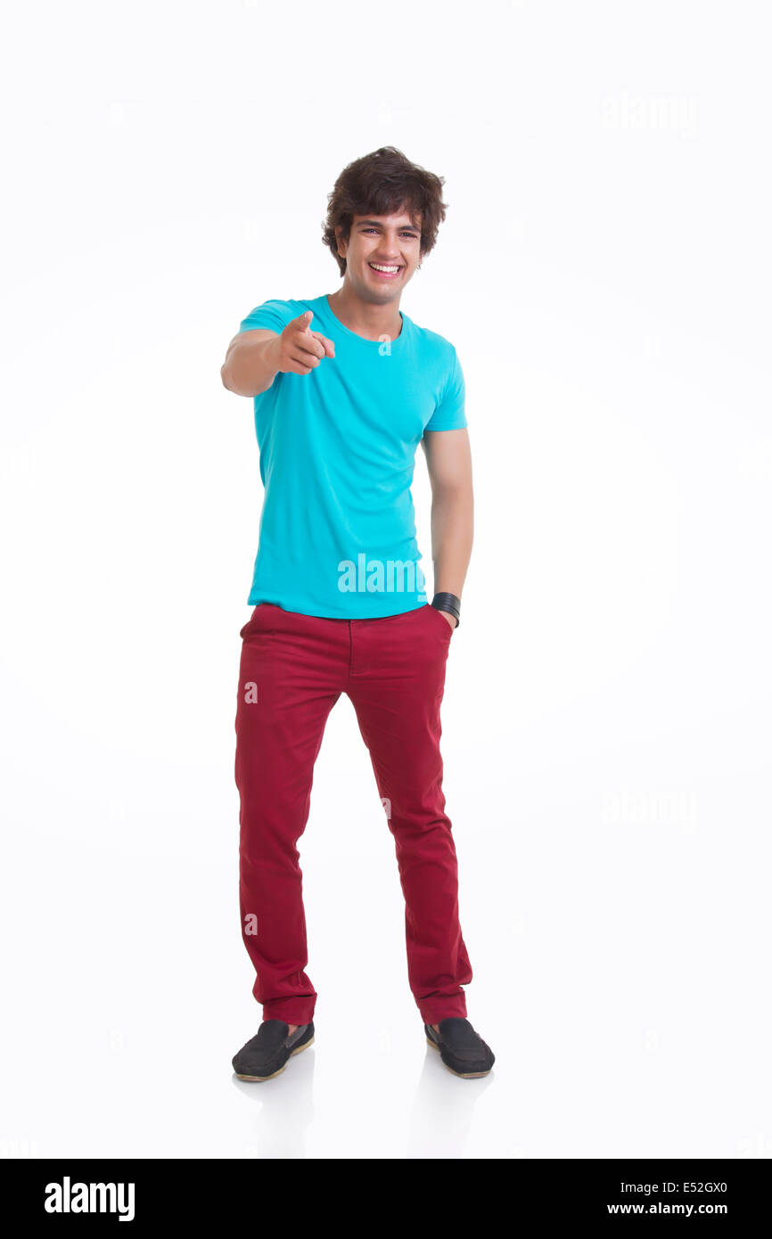 Full length portrait of handsome young man pointing at you over white ...