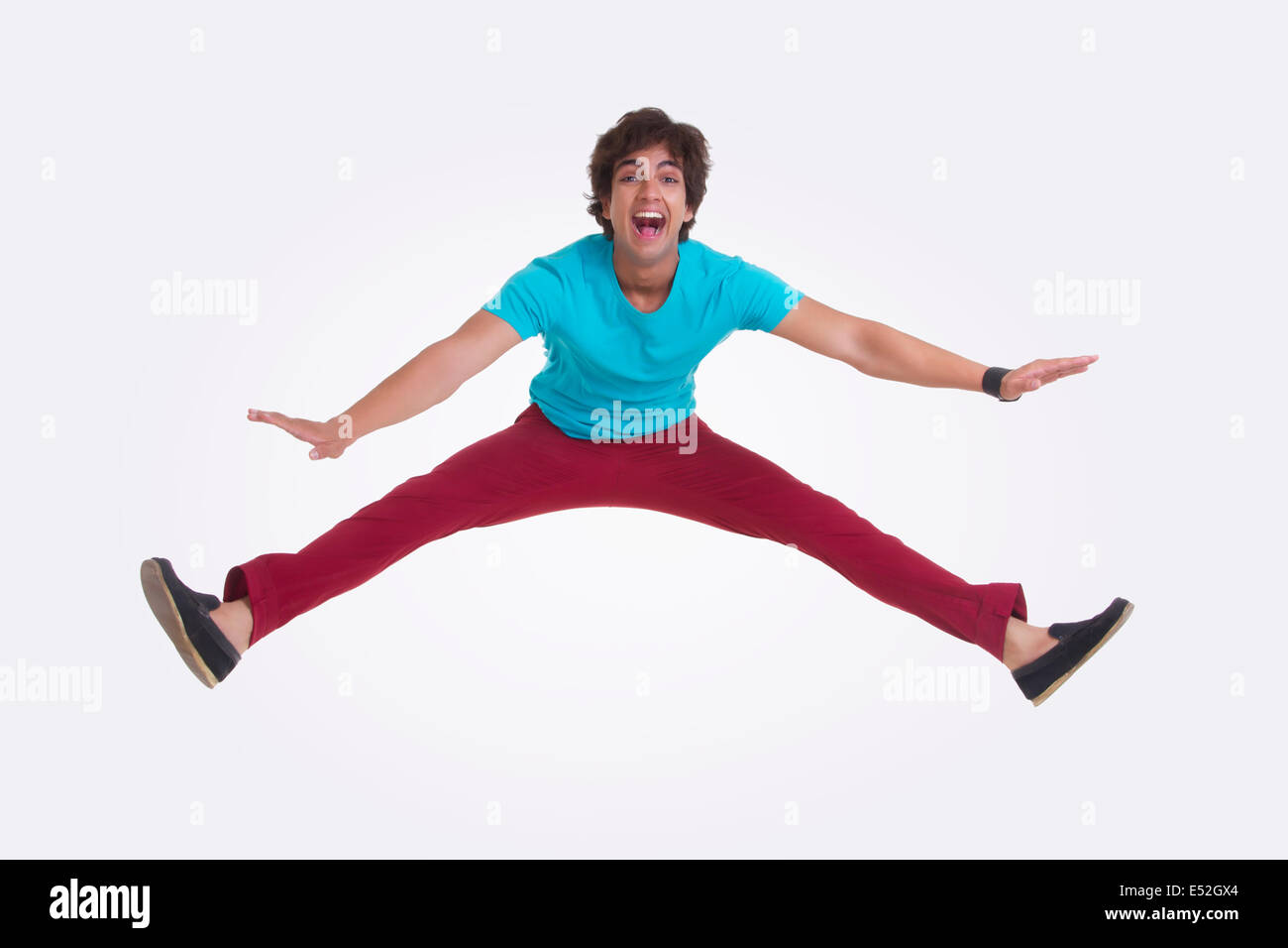 Full length portrait of excited young man jumping over white background ...