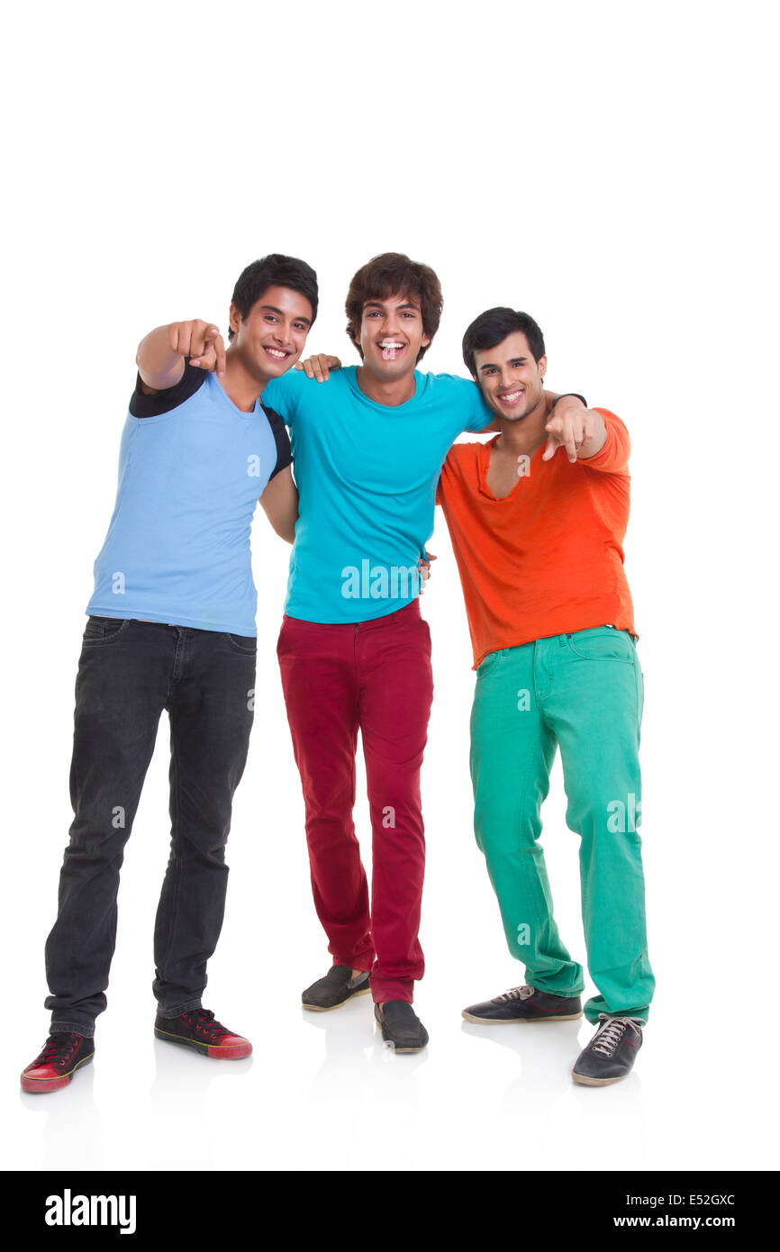 Full length of young male friends pointing at you over white background ...
