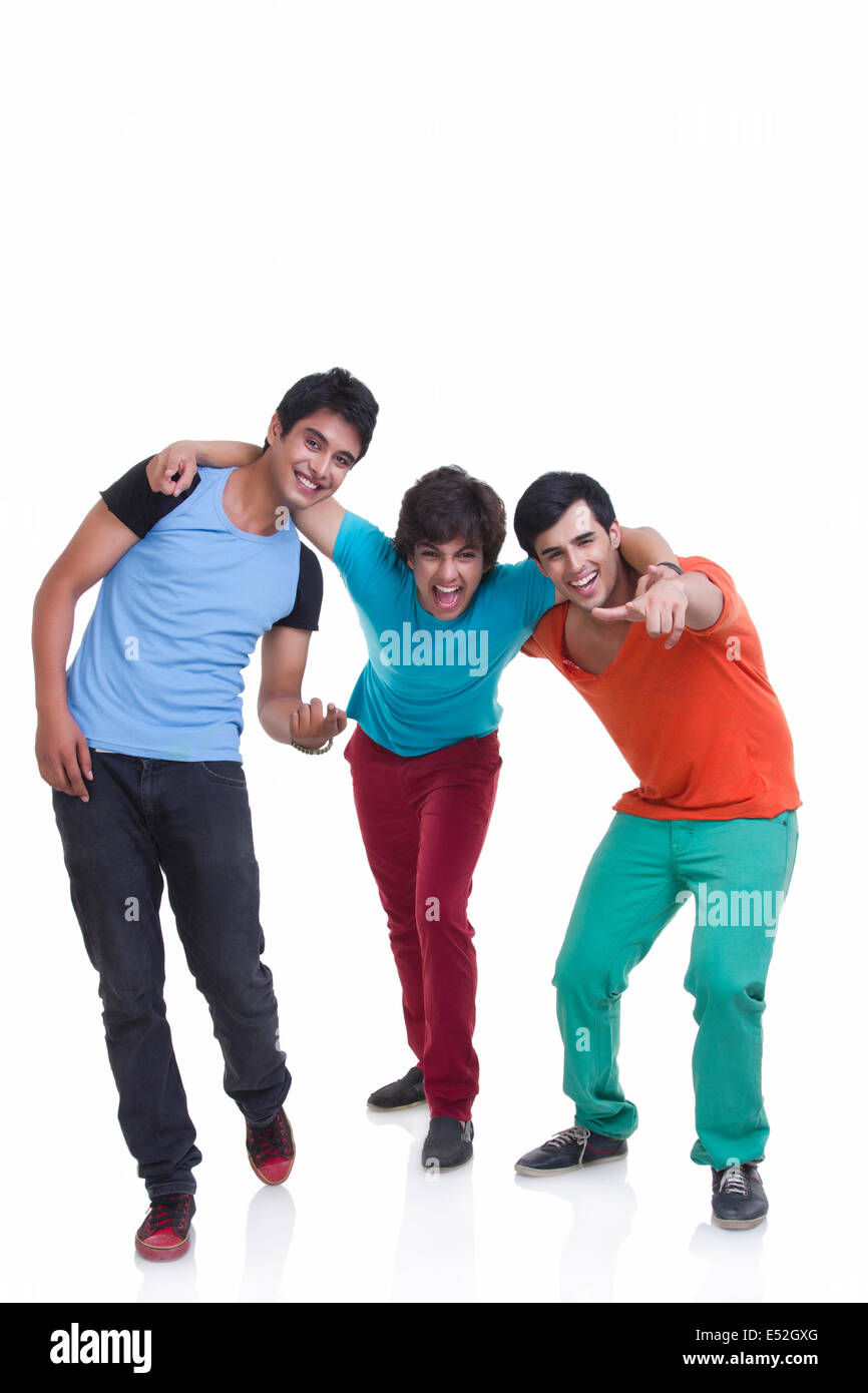 Full length of playful young male friends with arm around over white ...