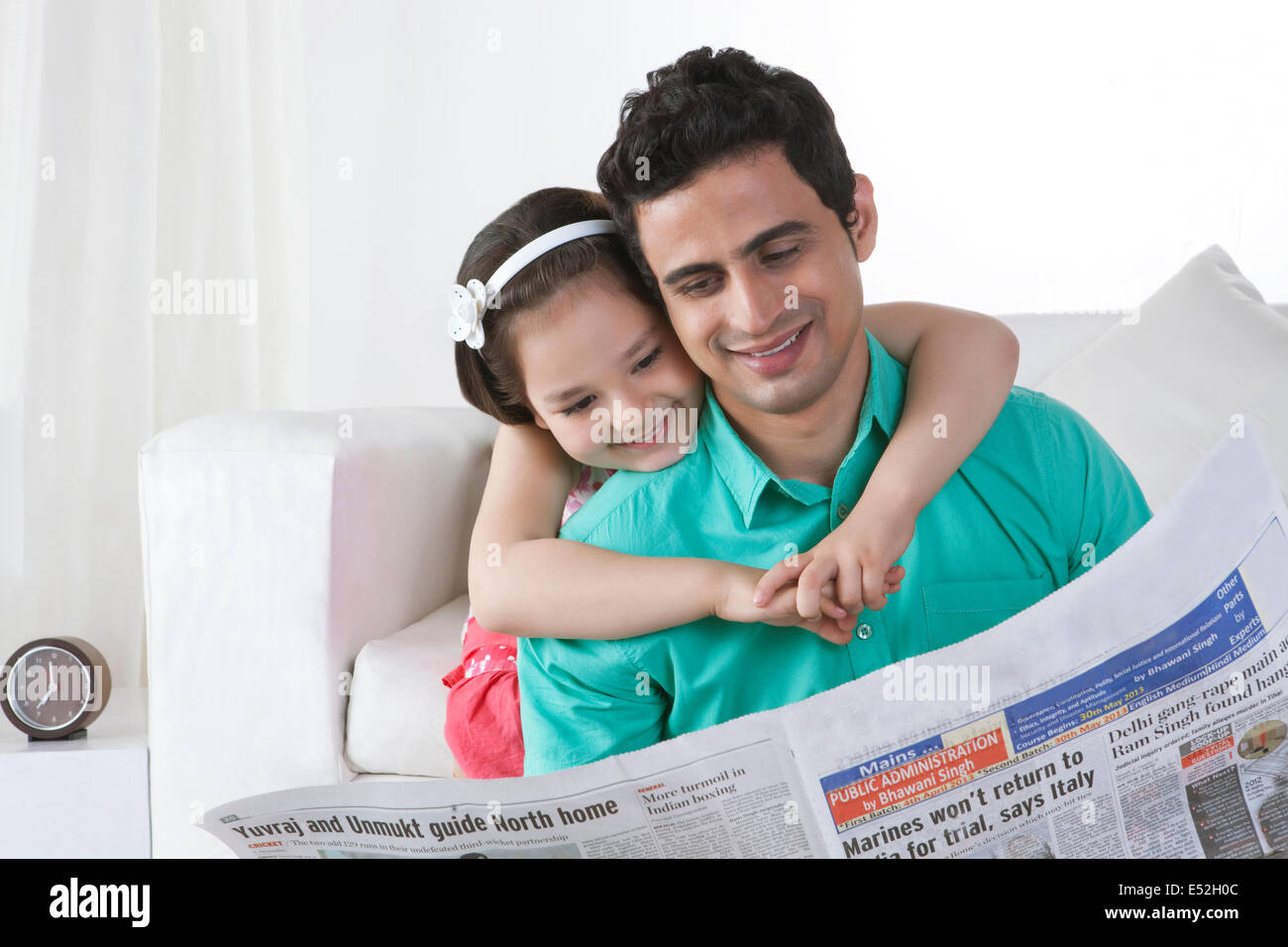 Loving girl and father reading newspaper in living room Stock Photo - Alamy
