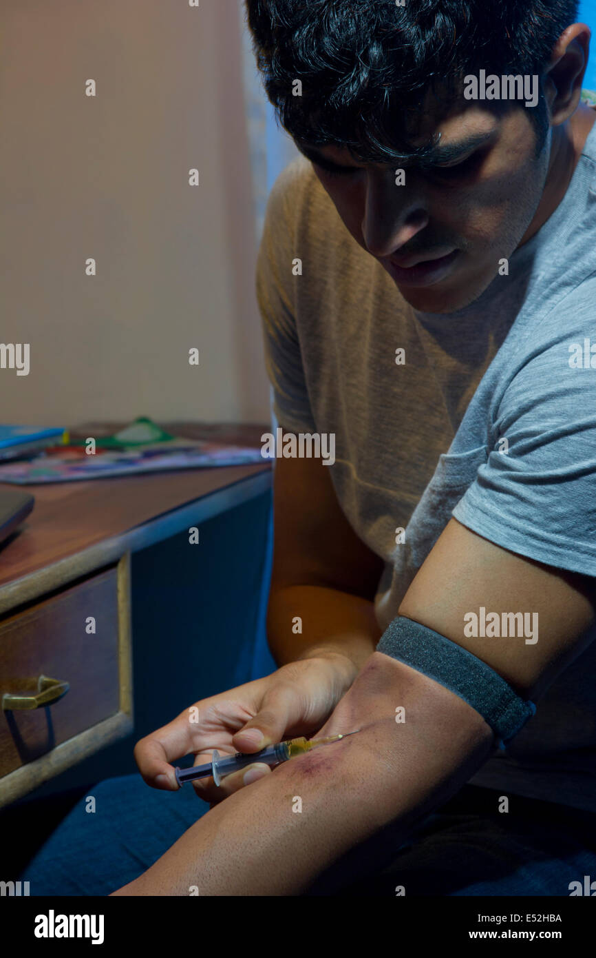Young addict injecting drugs on arm at home Stock Photo - Alamy