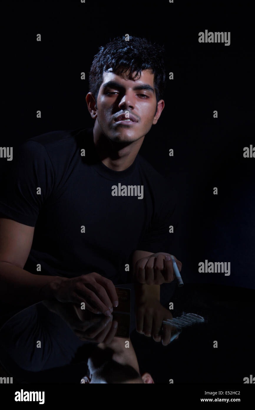 Portrait of young drug addict with cocaine and rolled up banknote Stock ...