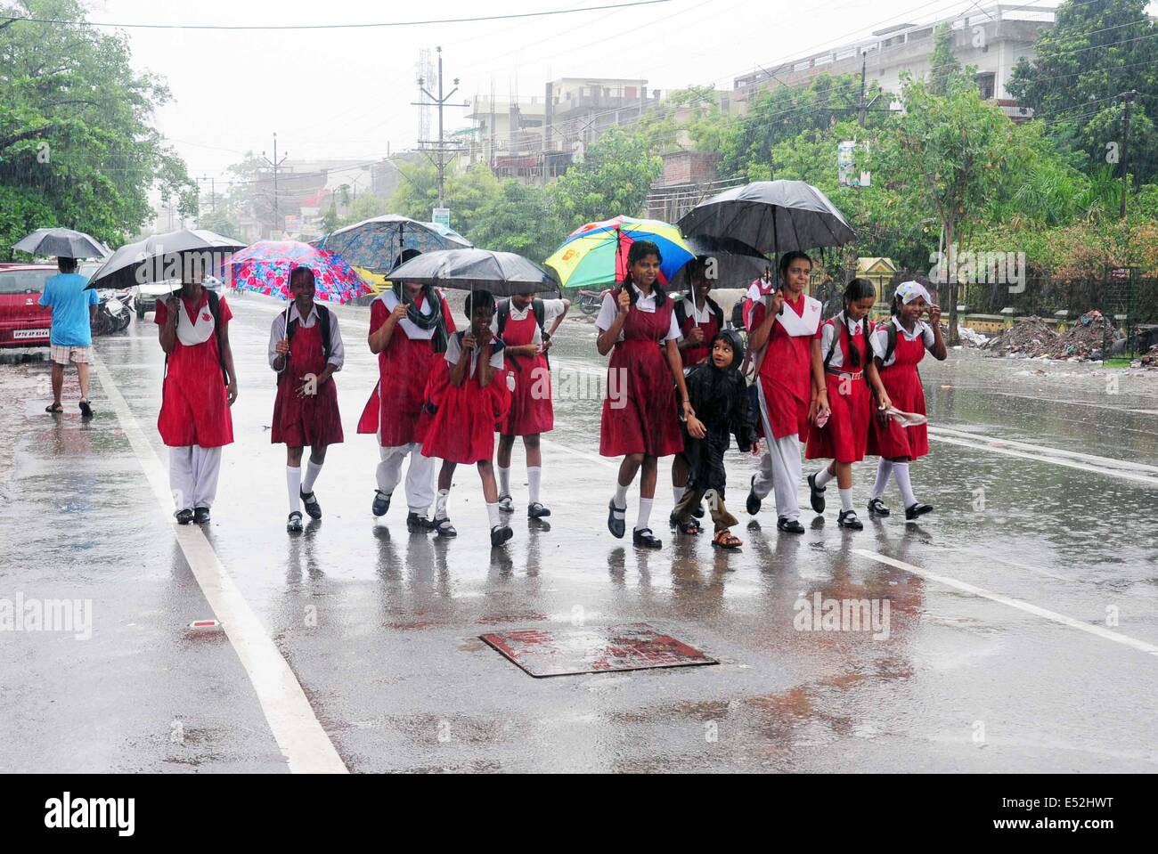 Allahabad, India. 18th July, 2014. School children safe themselves from ...