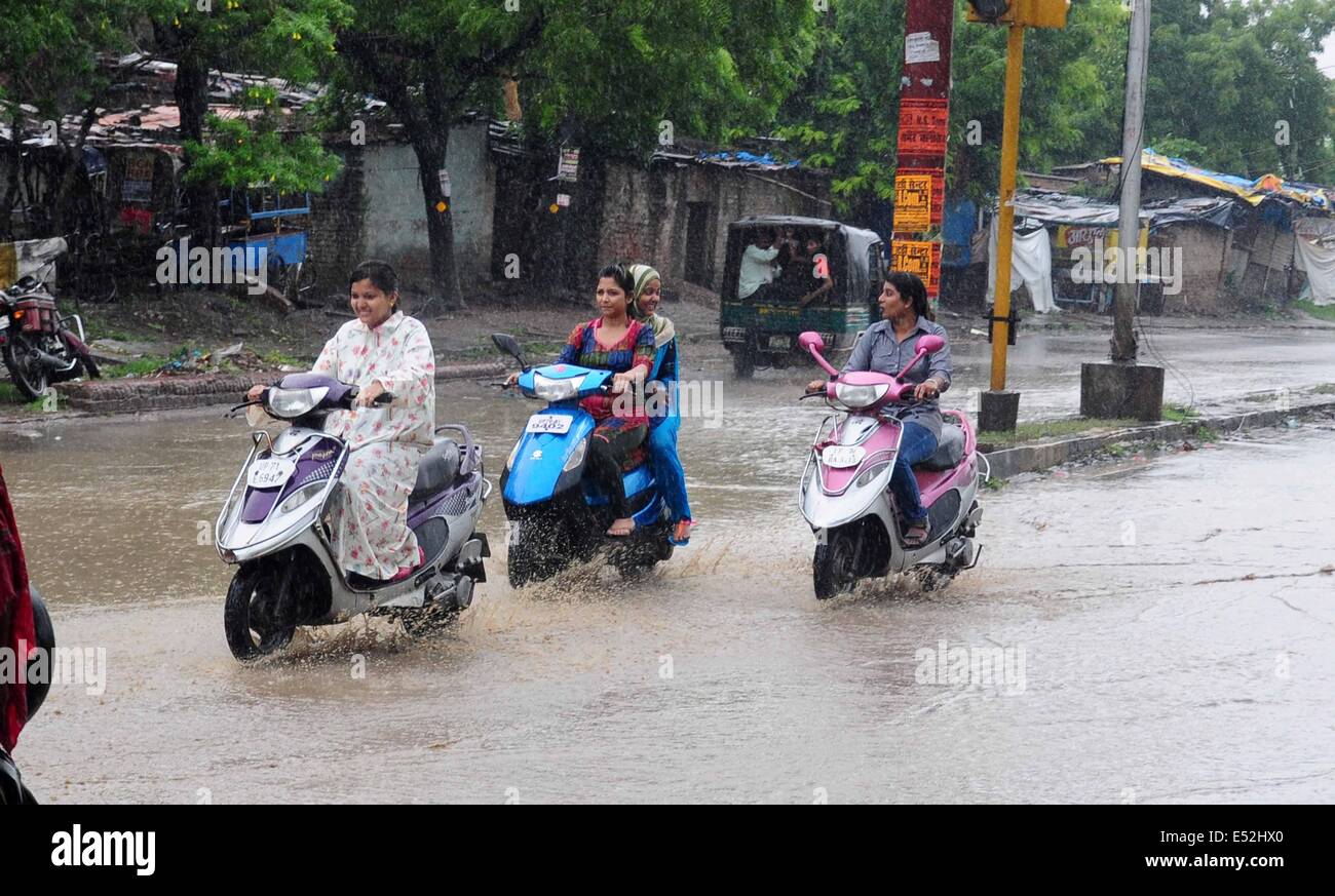 Allahabad, India. 18th July, 2014. Girls ride scooter through a flooded ...