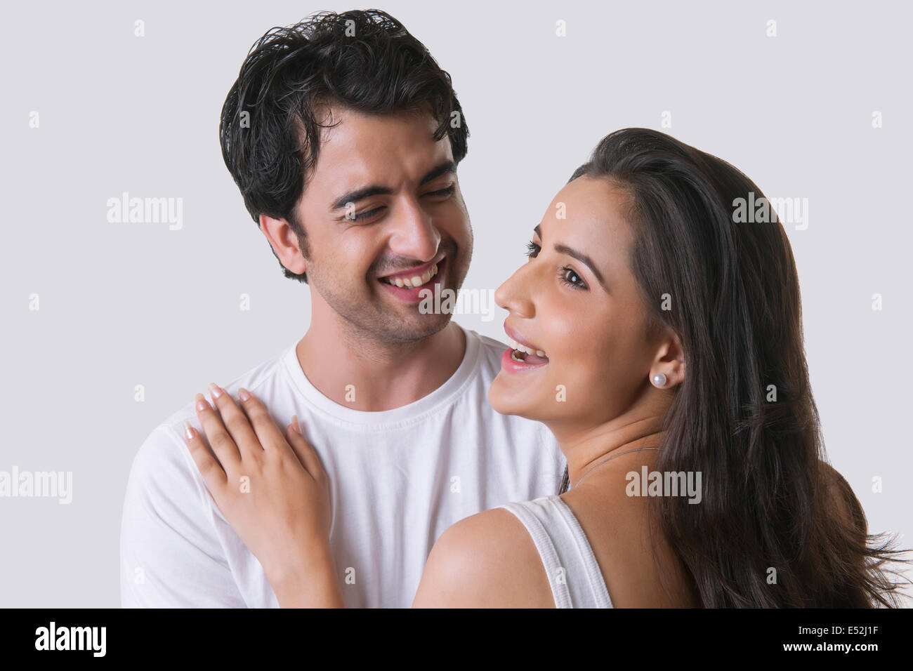 Happy young couple against white background Stock Photo - Alamy