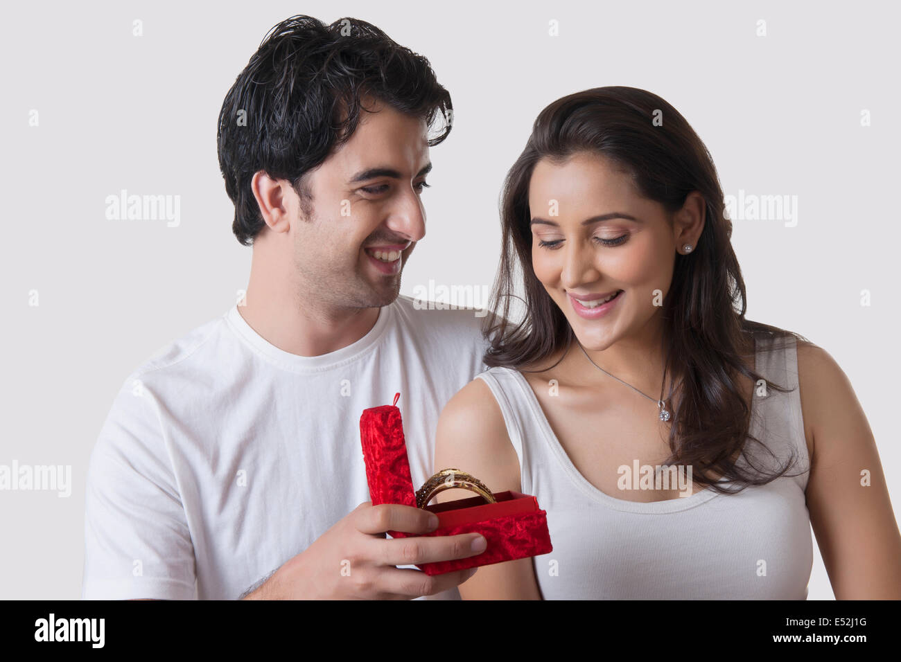 Happy man gifting bangles to woman against white background Stock Photo ...