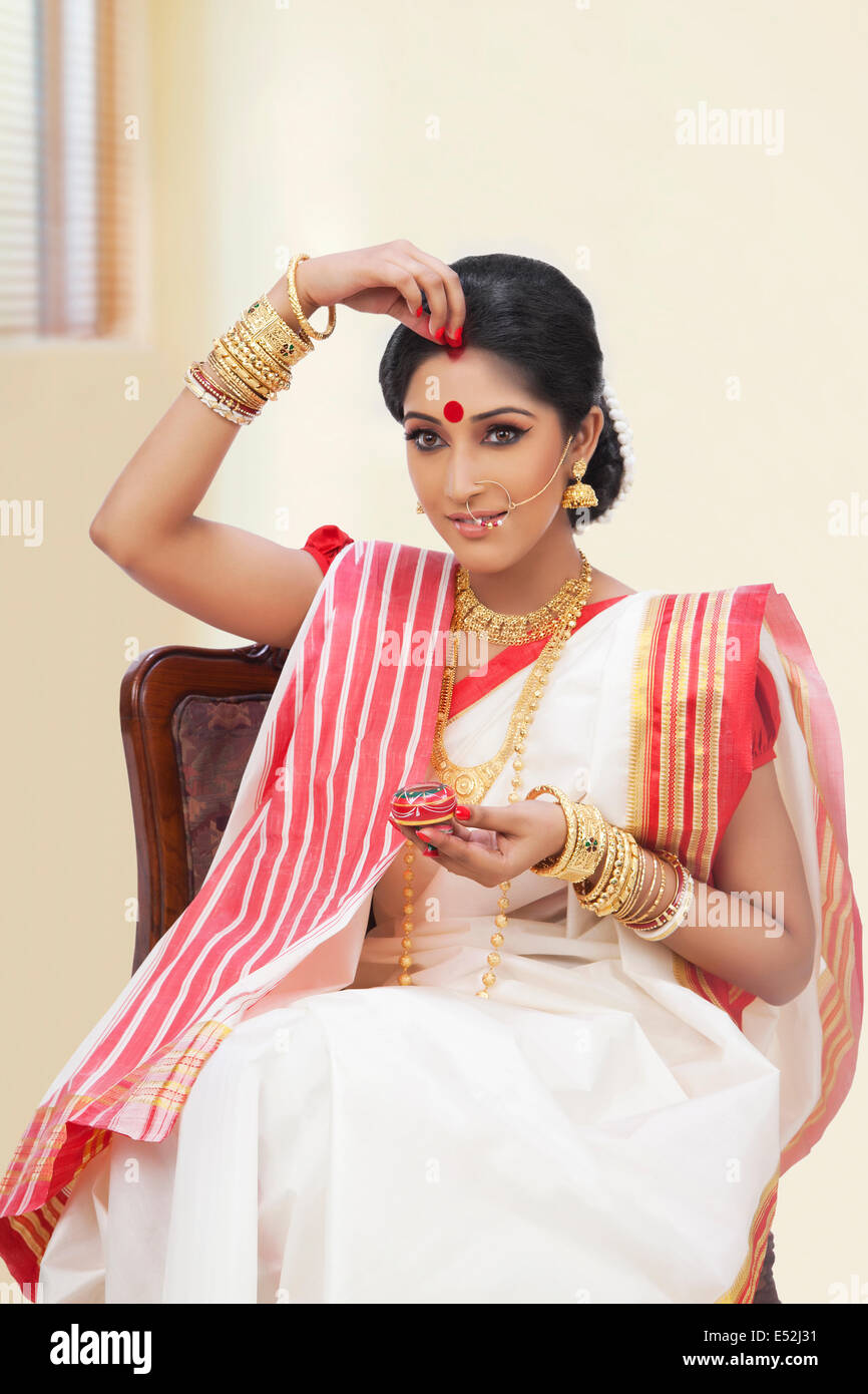 Bengali woman putting sindoor on her forehead Stock Photo - Alamy