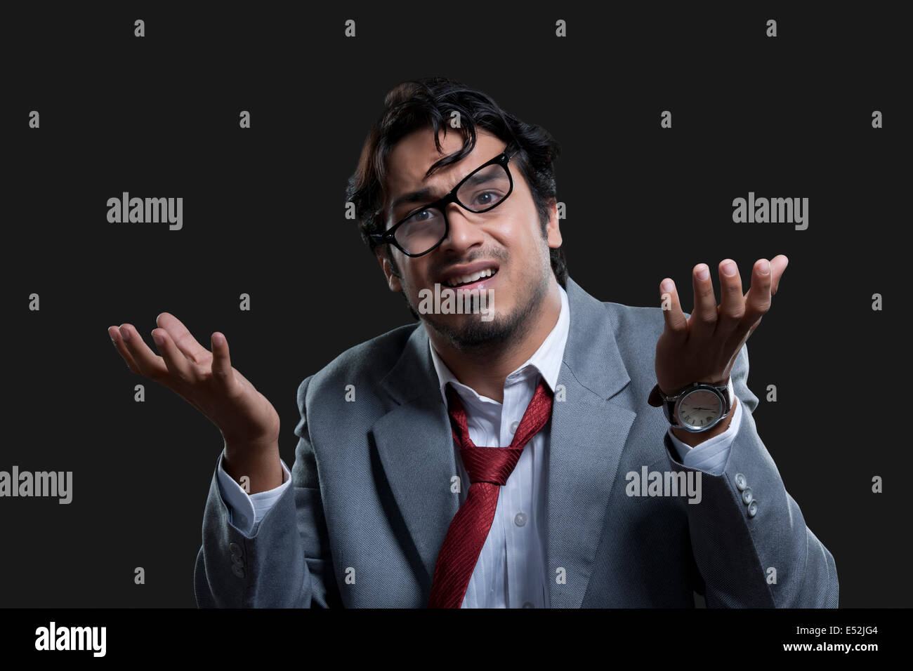 Frustrated businessman gesturing against black background Stock Photo ...