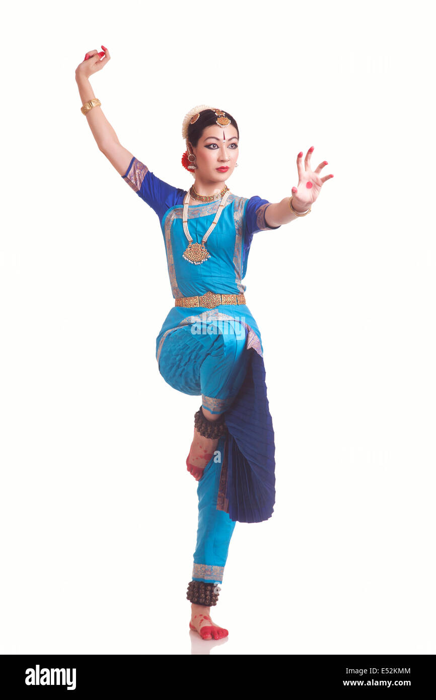 Full length of young woman performing classical dance on white ...