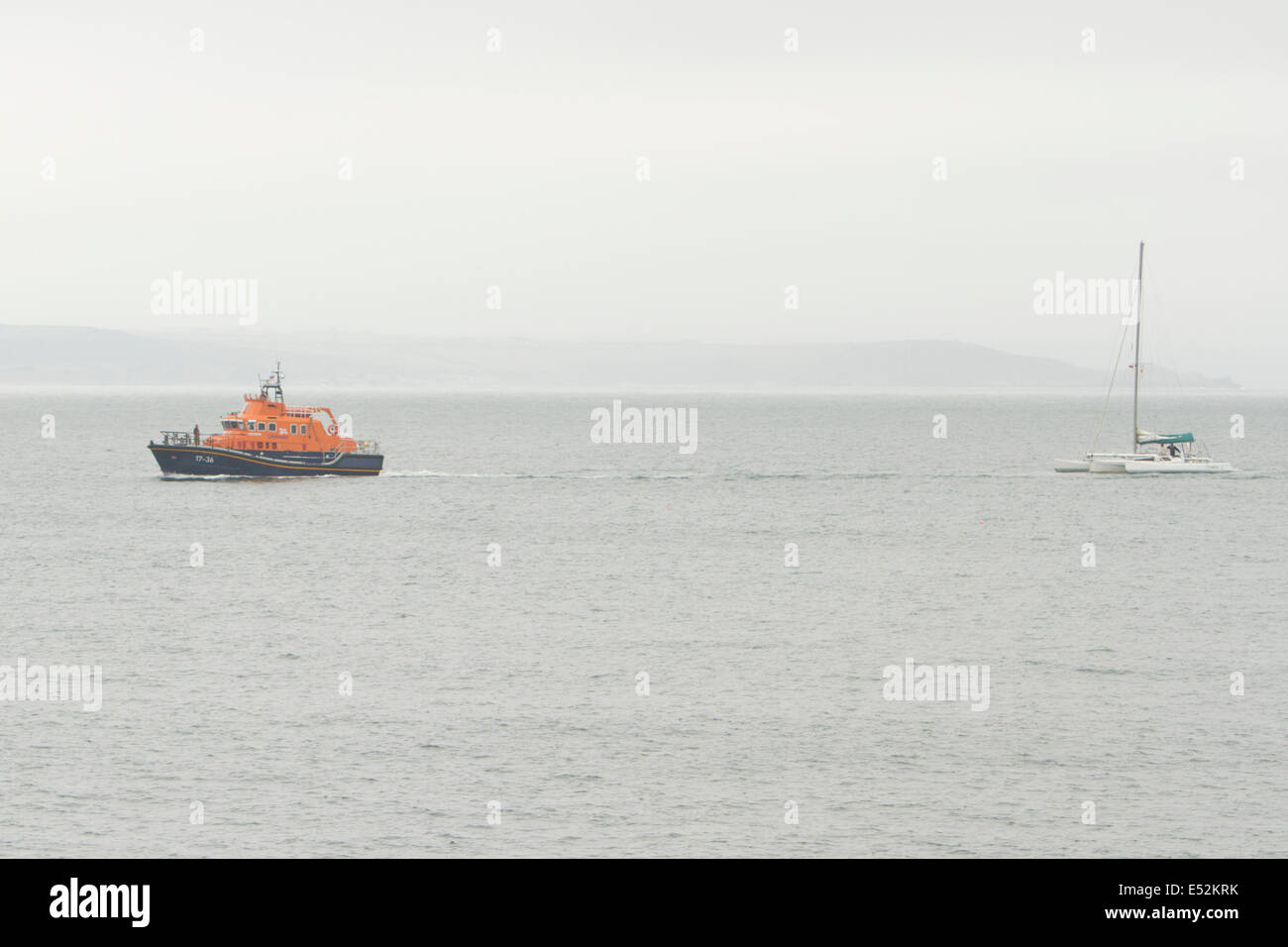 Newlyn, UK. 18th July, 2014. The Penlee RNLI Lifeboat tows a 30 foot ...
