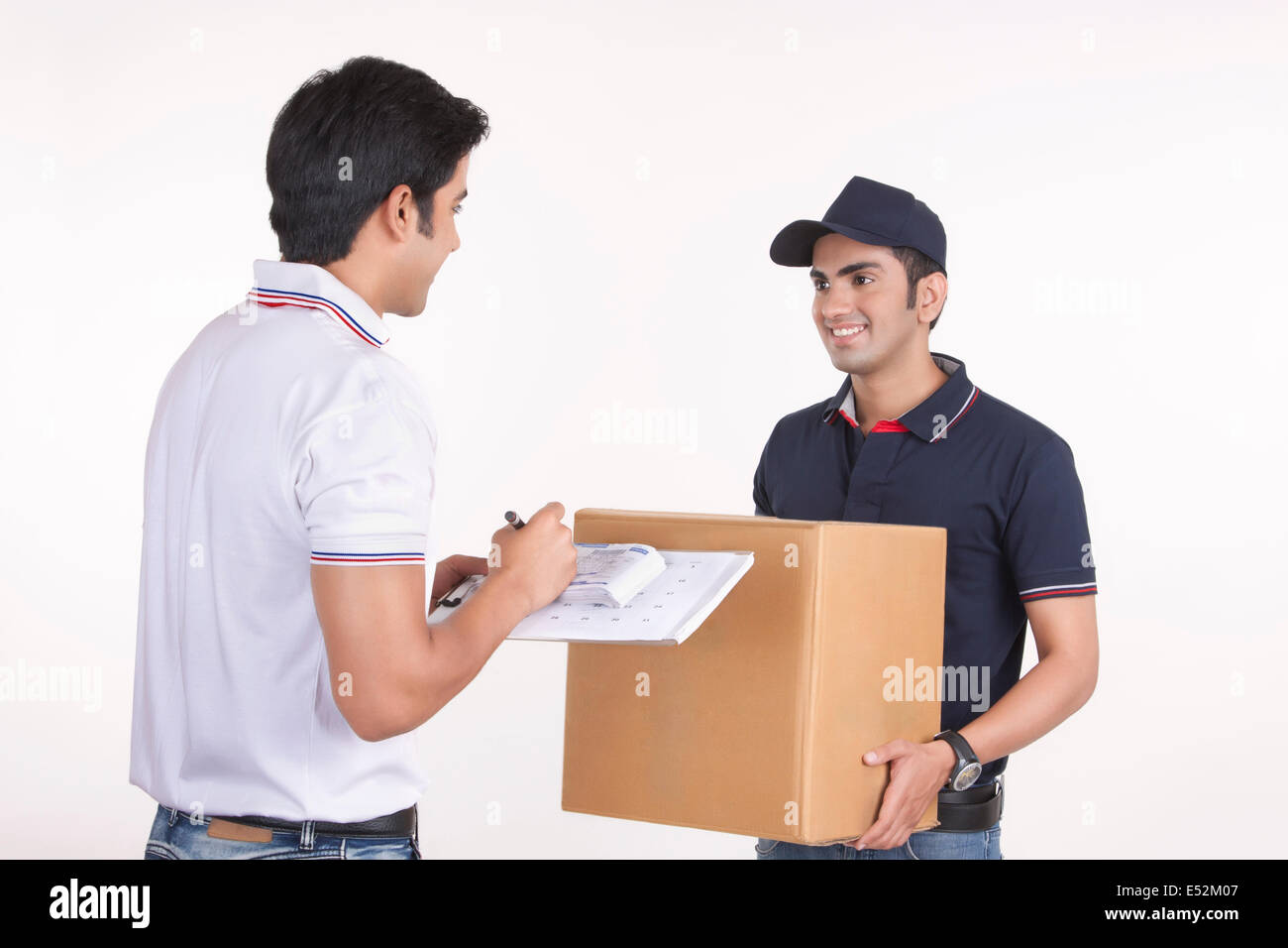 Man signing for package from delivery man against white background ...