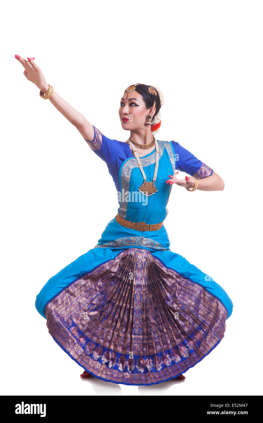 Full length of dancer performing Bharatanatyam against white background ...