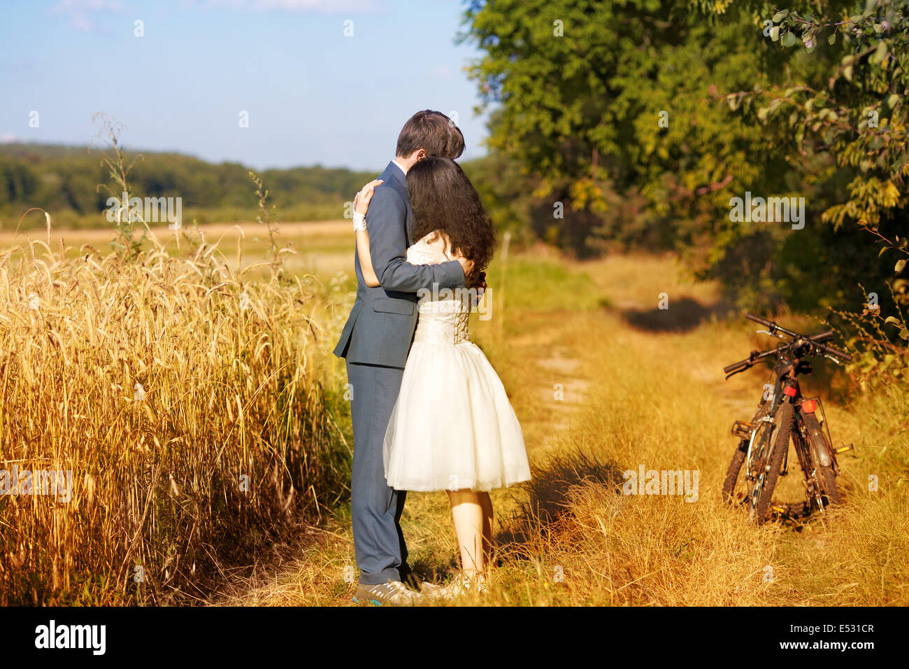 Young happy wedding couple hugging near wheat field Stock Photo - Alamy
