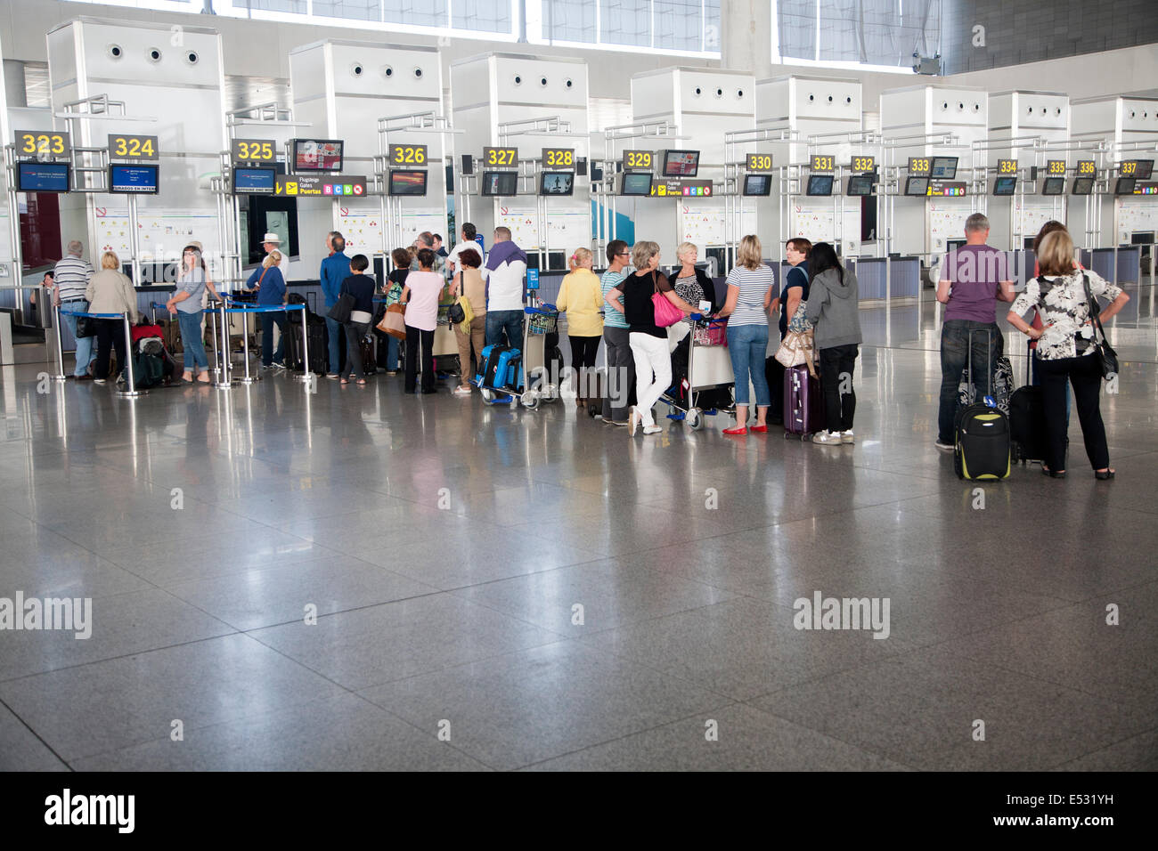 People waiting to check in inside Malaga airport, Spain Stock Photo - Alamy