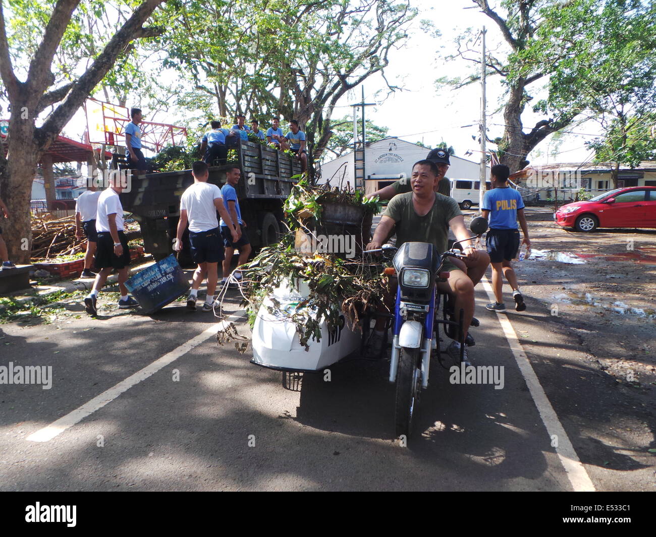 LUCENA CITY, PHILIPPINES – JULY 18, 2014: Policemen and Army cleaning ...