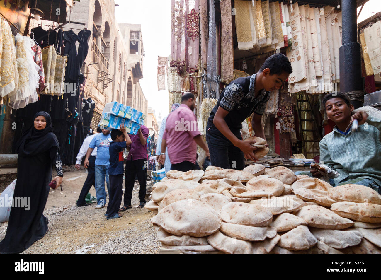 Bazaar street scene with child selling bread. Islamic Cairo, Egypt ...
