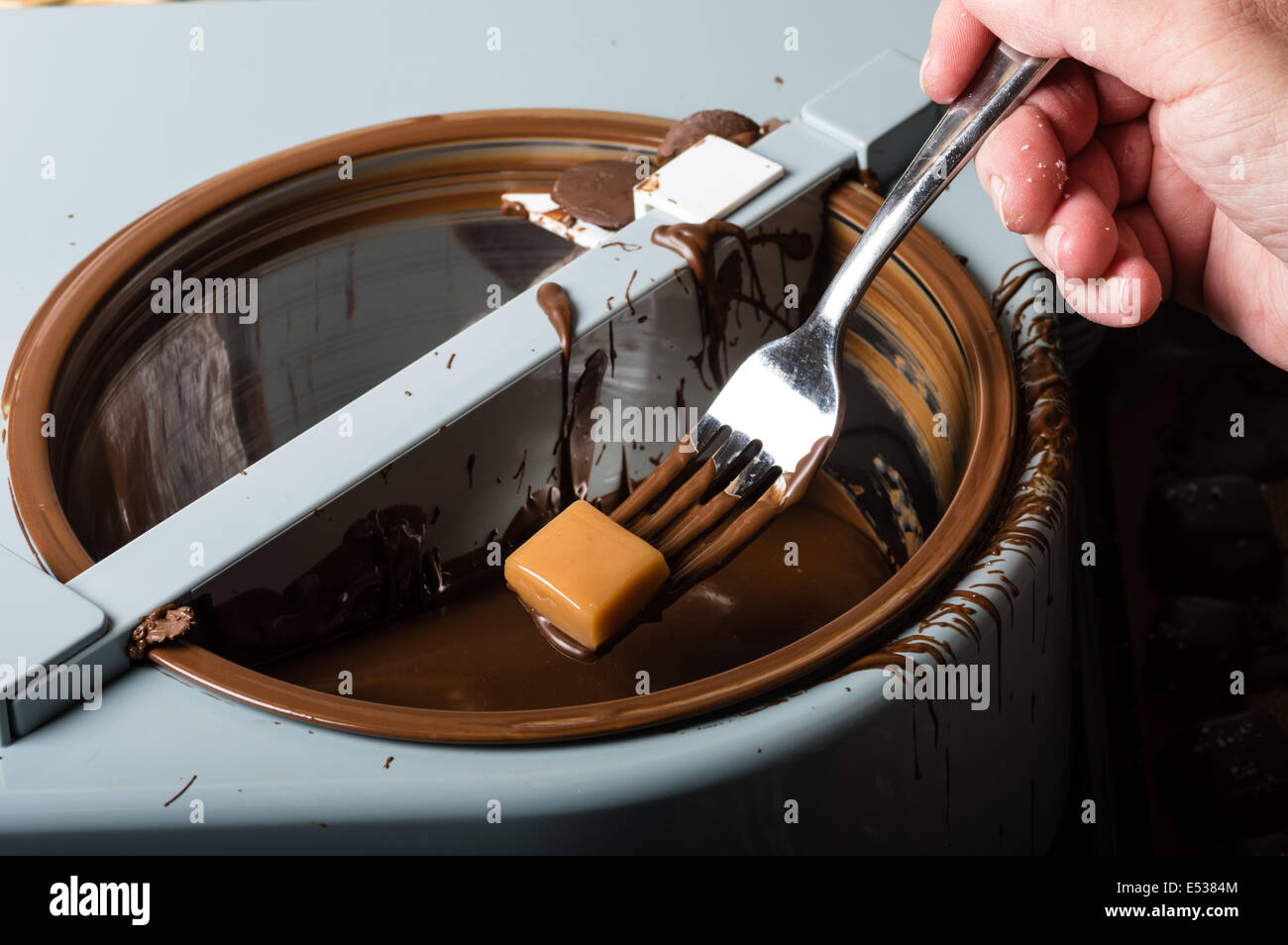 Candy maker using a chocolate coating machine to make candy Stock Photo ...