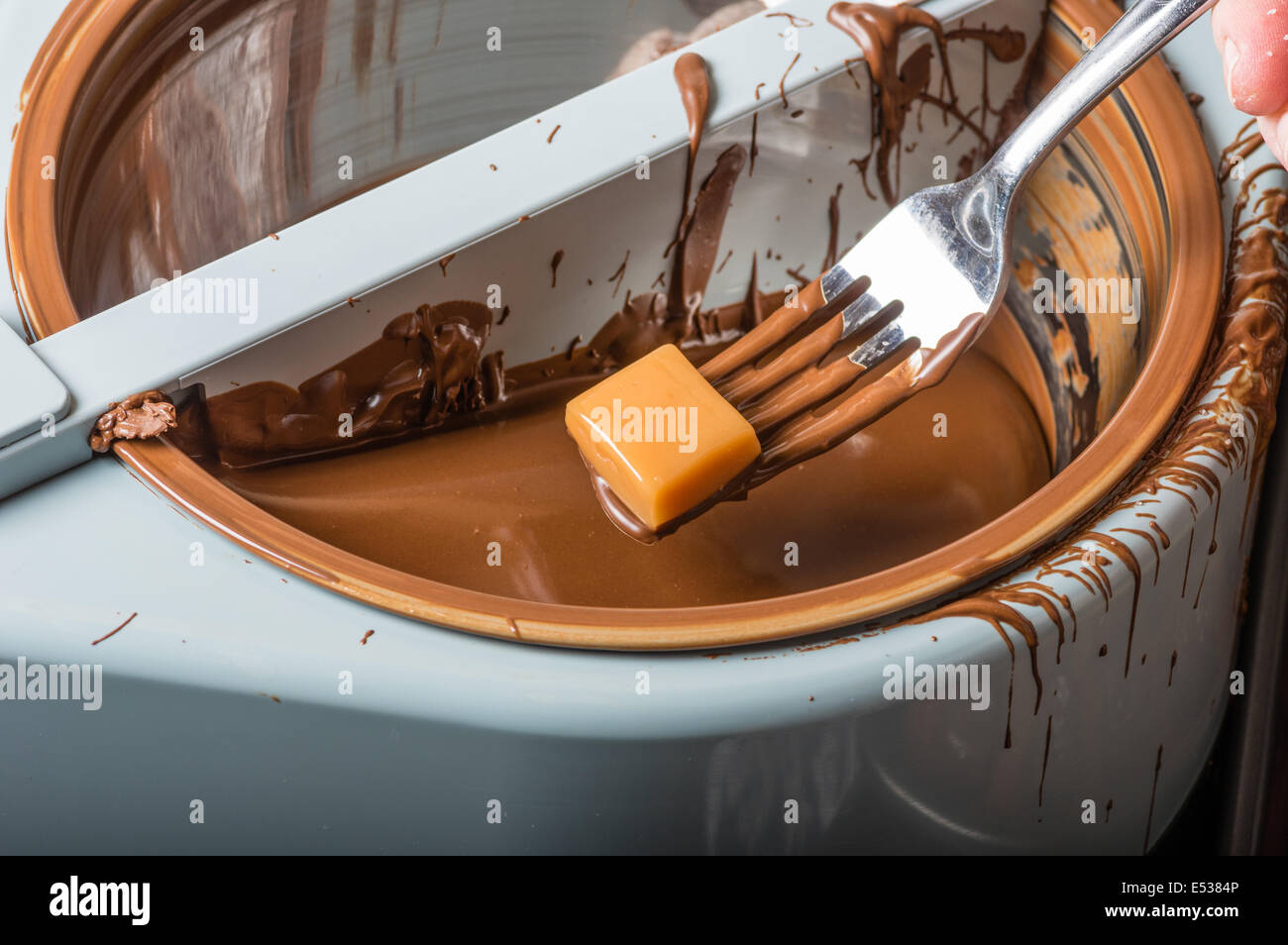 Candy maker using a chocolate coating machine to make candy Stock Photo ...