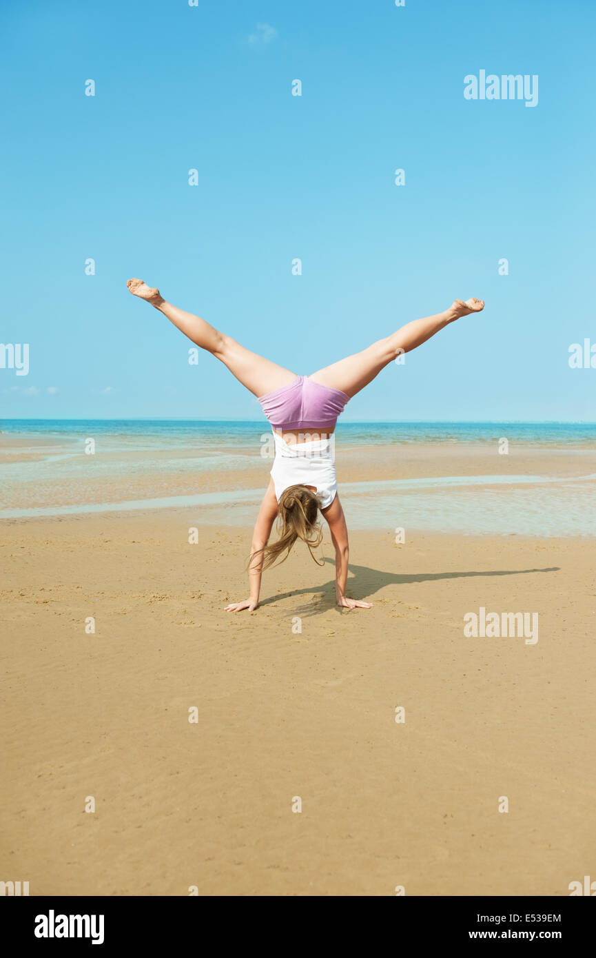 Barefoot young woman doing handstand beach hi-res stock photography and images - Alamy
