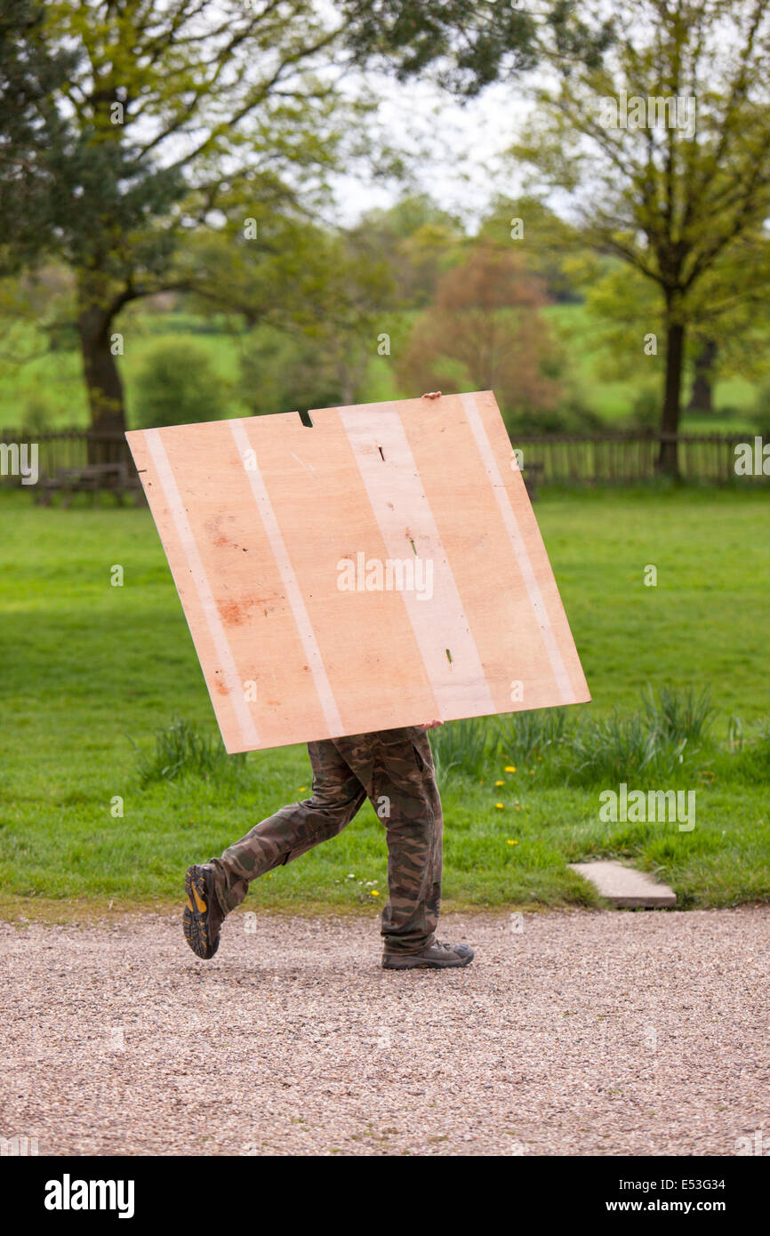 Workman carrying a large piece of board, England UK Stock Photo - Alamy