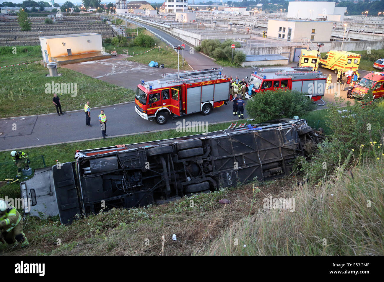 A damaged coach lies on its side on a slope with rescue and emergency ...