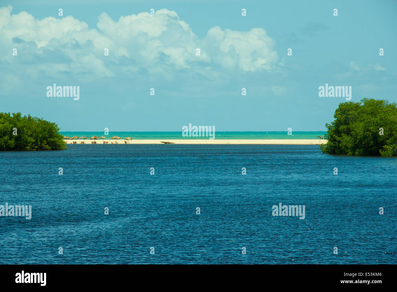 A line of sand separating the blue sea from the dark river Stock Photo ...