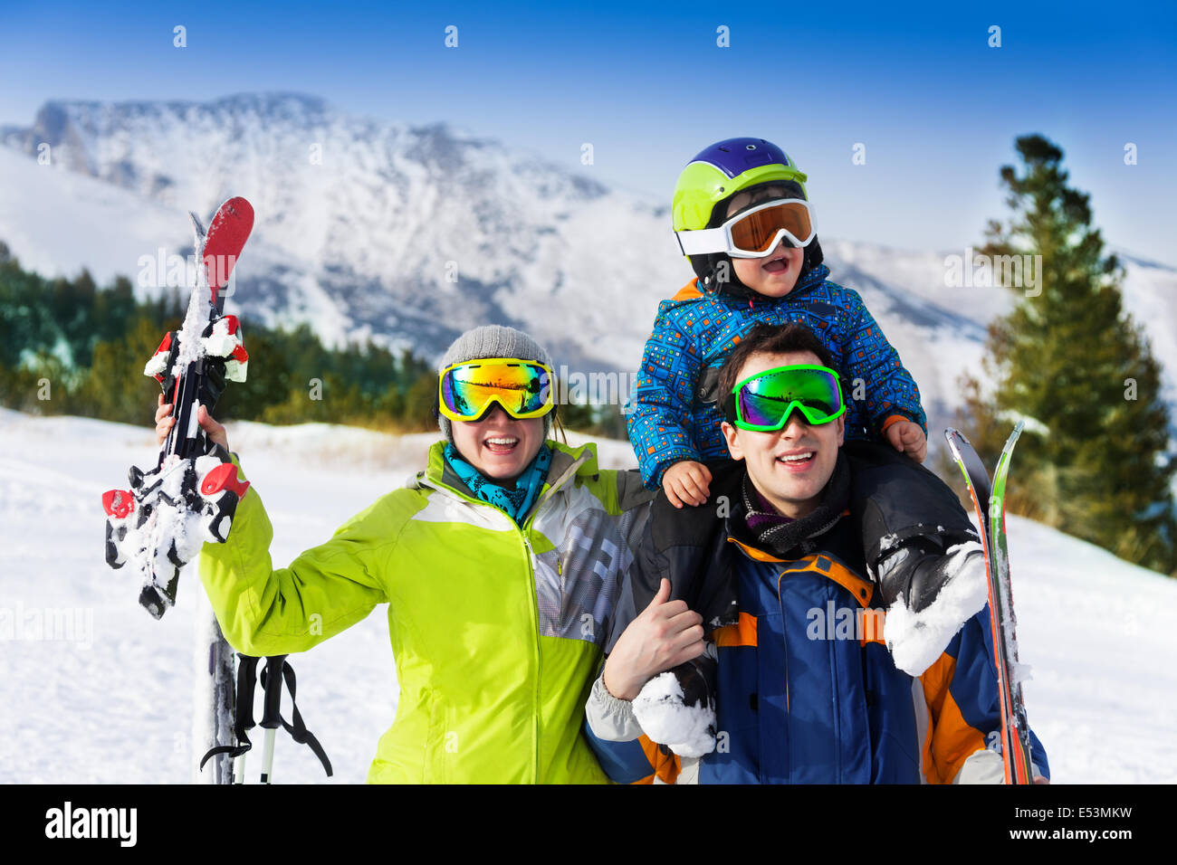 Parents and child on dad's shoulders in ski masks Stock Photo - Alamy