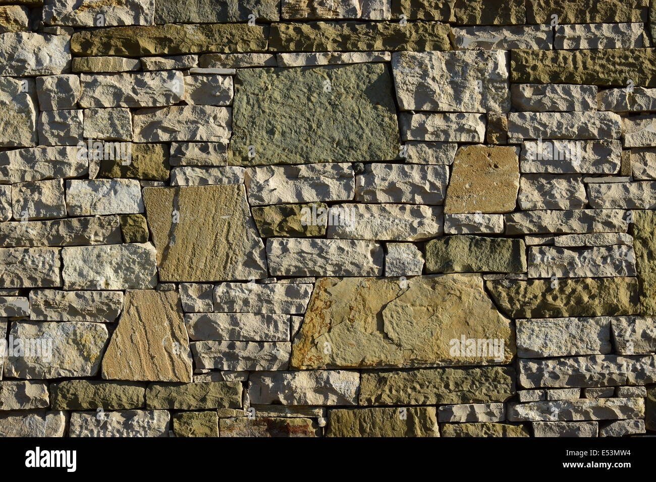 Decorative wall made of gray flat schist stones and green and yellow ...