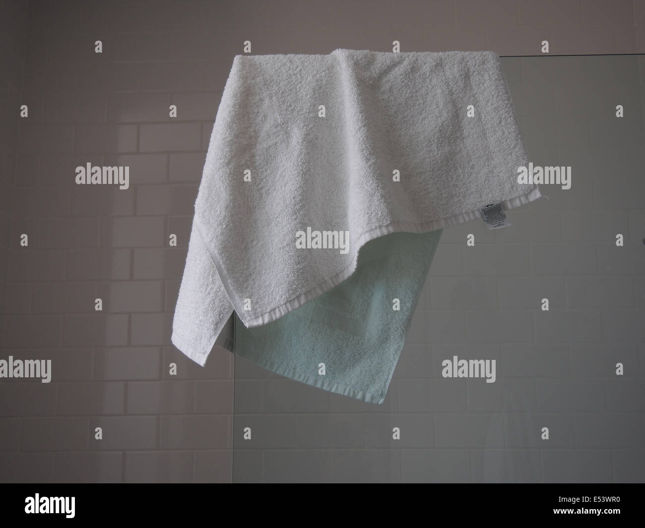 White bath towel hung to dry on glass shower enclosure, USA, June 15 ...