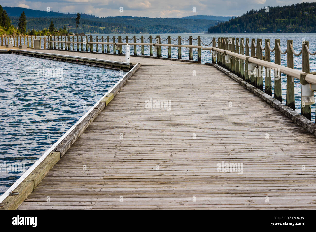 A wooden walkway extending into a lake as a dock or boat access Stock ...