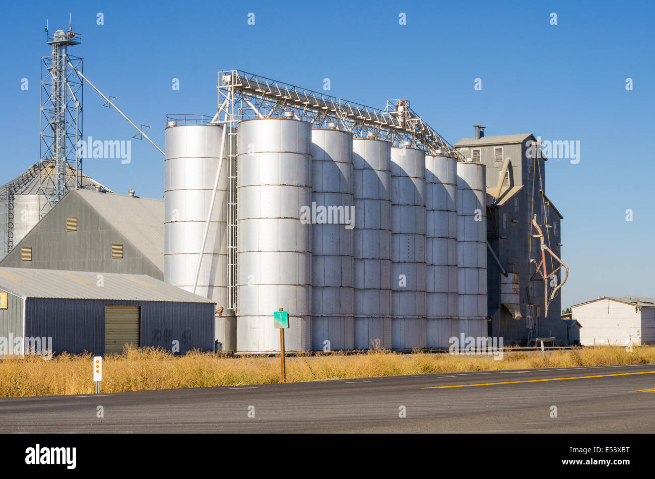 Metal silos and grain elevators at a rural mill Stock Photo - Alamy