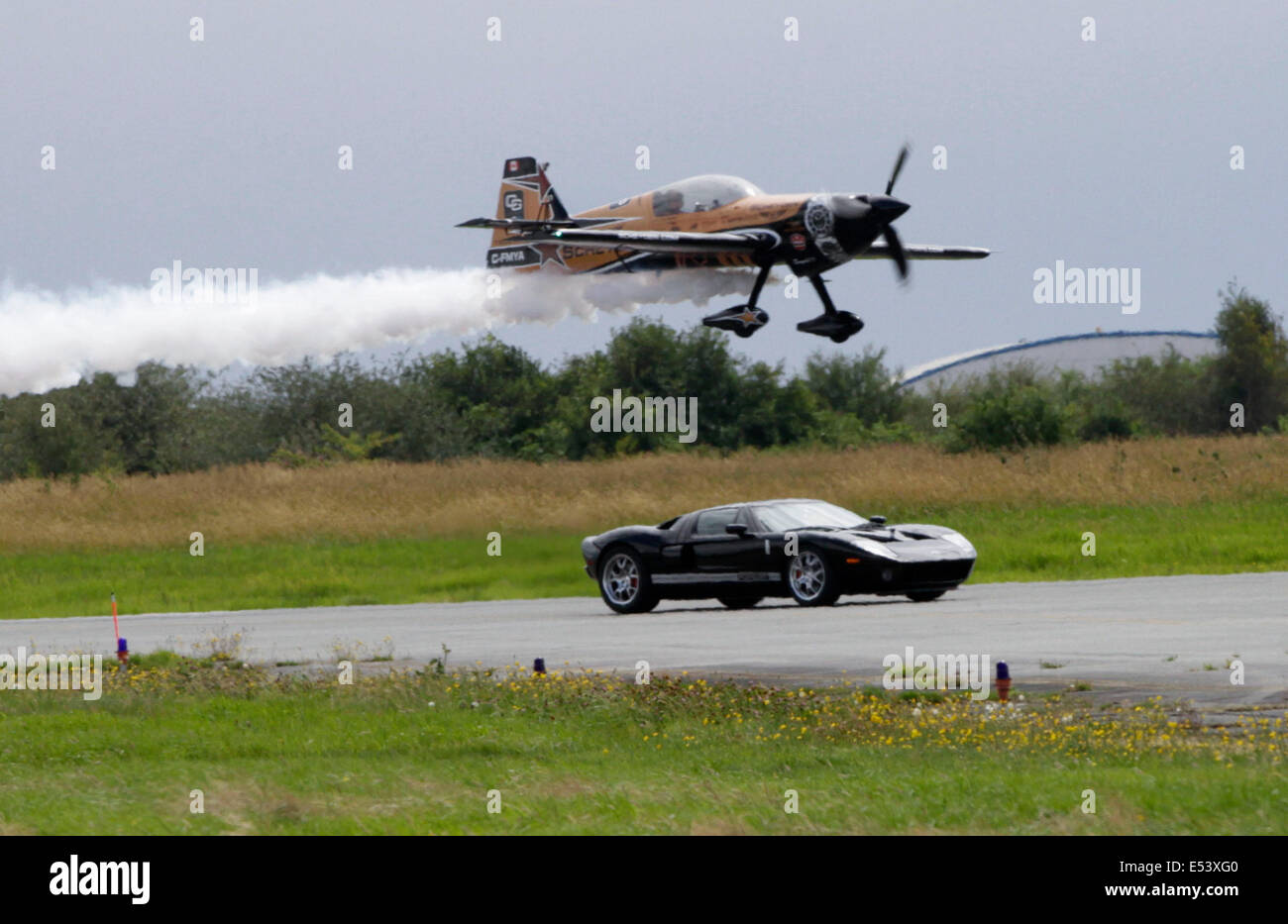 Vancouver, Canada. 19th July, 2014. An aircraft races with a racing car ...