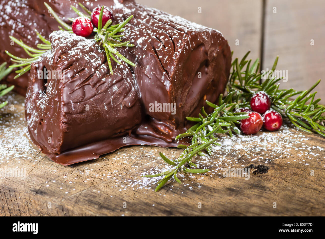Chocolate Yule log with green branches and cranberries Stock Photo - Alamy
