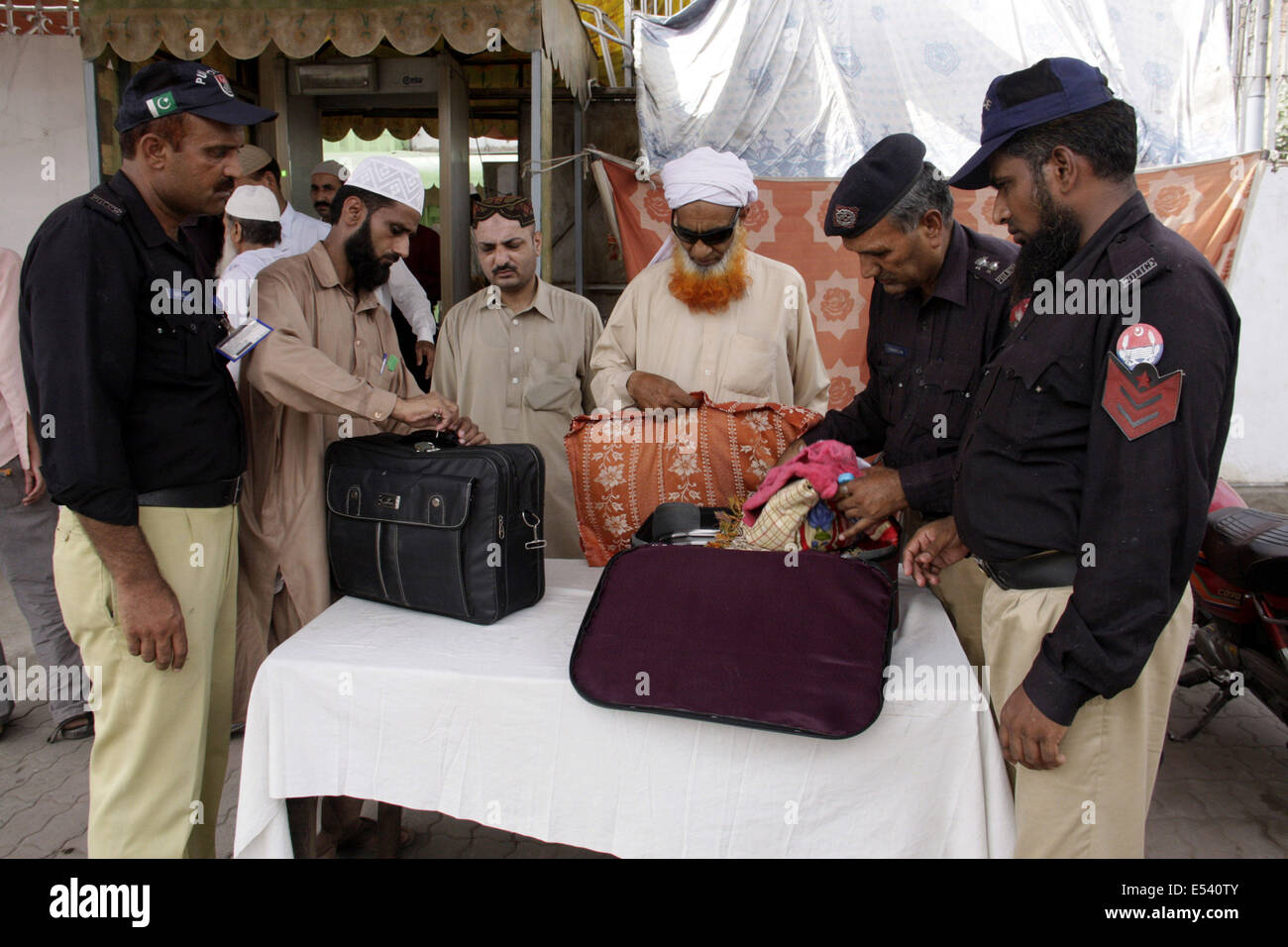 Lahore. 19th July, 2014. Pakistani policemen check belongings of ...
