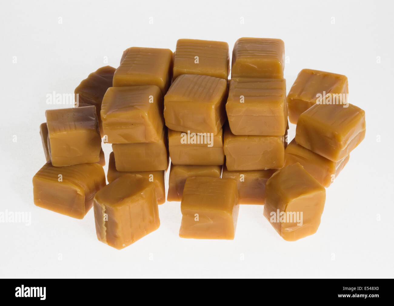 A neat stack of caramel cubes isolated on white Stock Photo - Alamy