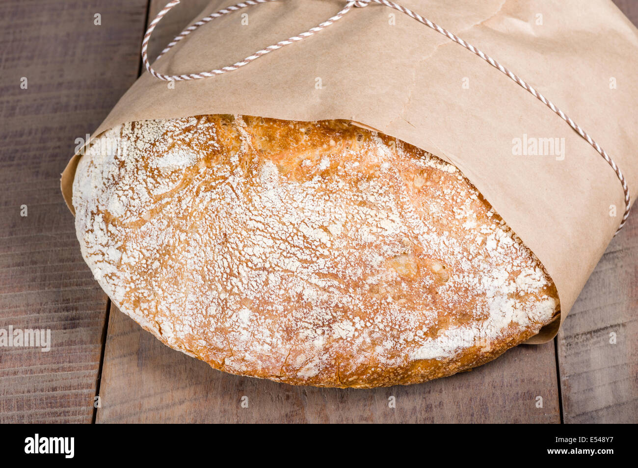 A loaf of fresh baked bread wrapped in paper Stock Photo - Alamy
