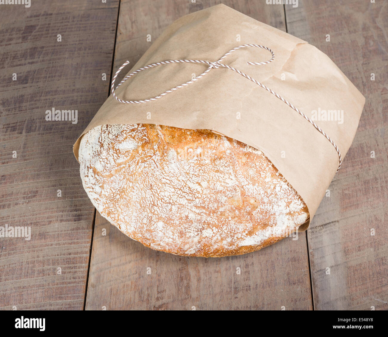 A loaf of fresh baked bread wrapped in paper Stock Photo - Alamy
