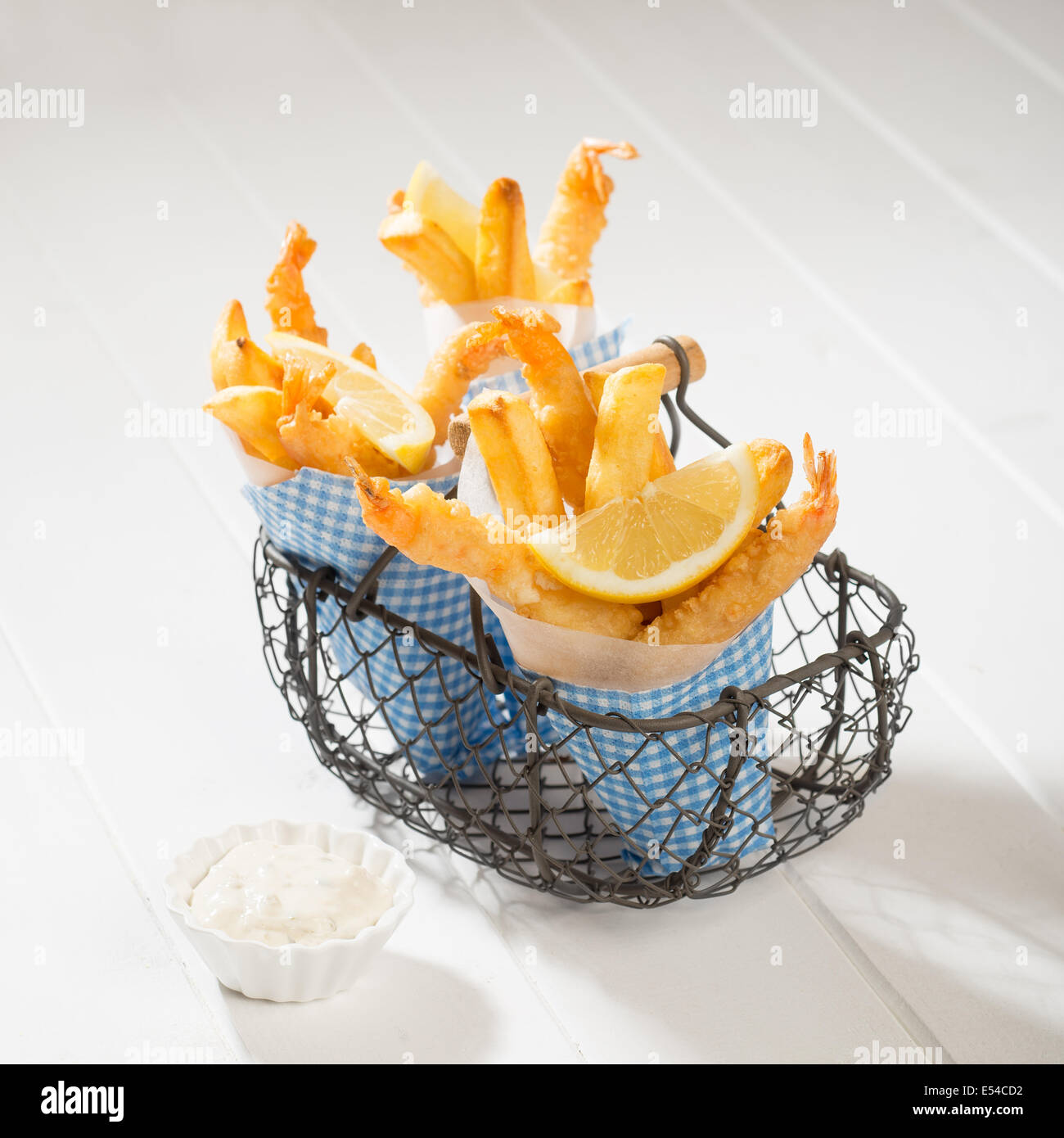 Tempura prawns with fries wrapped in cones with a dish of tartar sauce ...